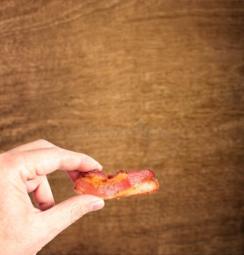 Hand Holding a Crispy Bacon Strip Stock Photo - Image of meat ...