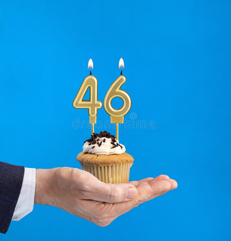 Hand Holding a Cupcake with the Number 46 Candle - Birthday on Blue ...