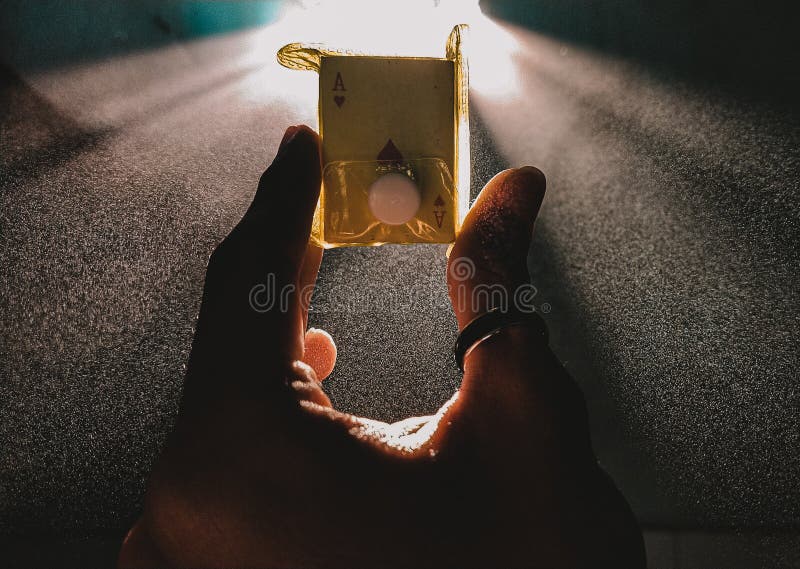 A Hand Holding a Deck of Cards Displaying Ace and Sunrays from Behind ...
