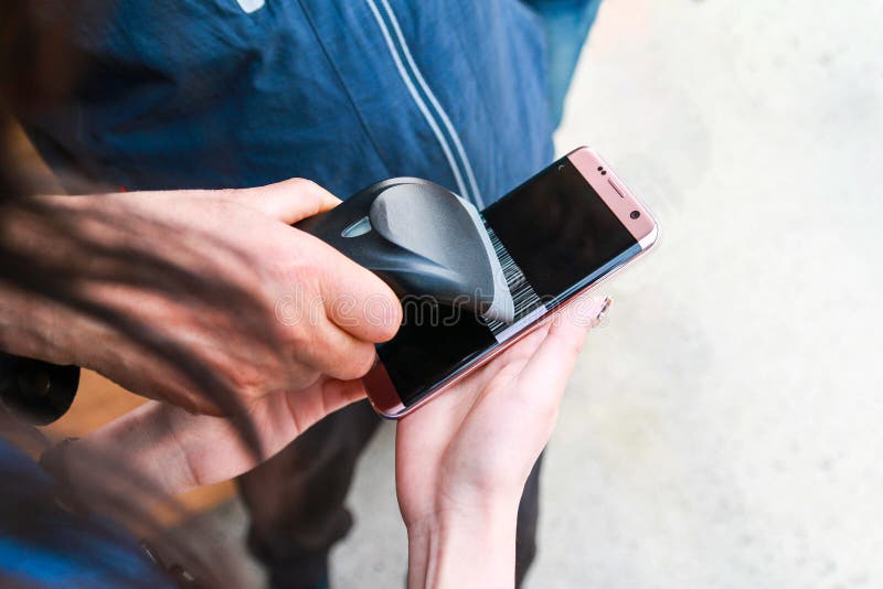 Hand Holding an Electronic Bar Code Scanner To Scan a Bar Code from a ...