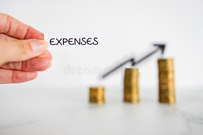 Hand Holding Expenses Text in Front of Growing Stacks of Coins with ...