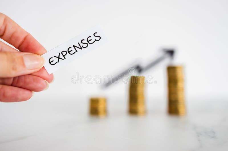 Hand Holding Expenses Text in Front of Growing Stacks of Coins with ...