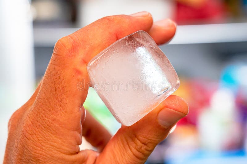 Hand Holding between the Fingers an Ice Cube, Solid Water Stock Photo ...
