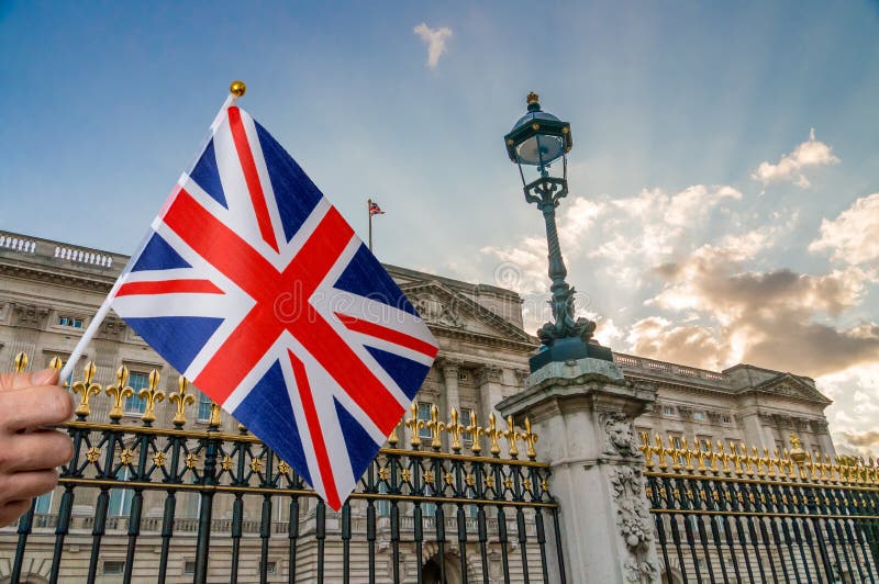 Hand is Holding Flag of Great Britain. Buckingham Palace in Background ...