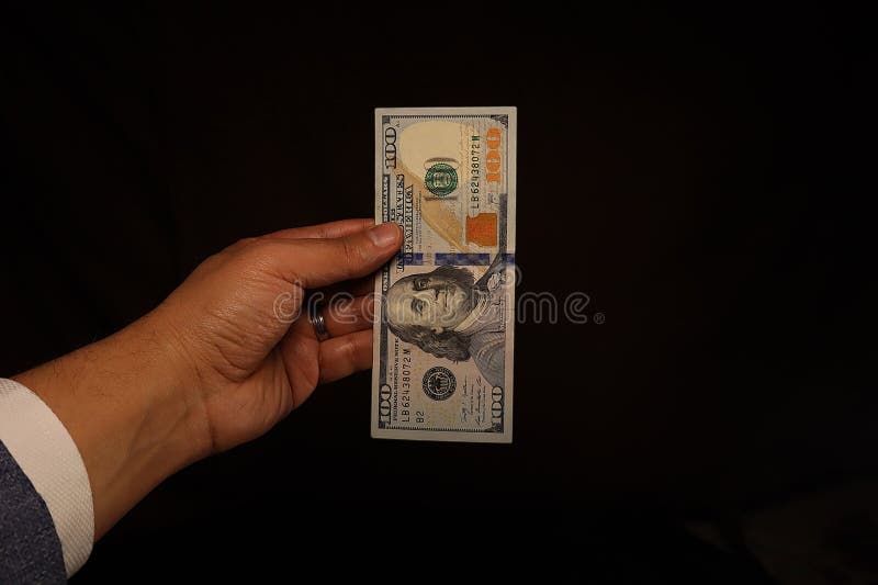 Hand Holding Front Side of $100 U.S. Bill Isolated on Black Background ...