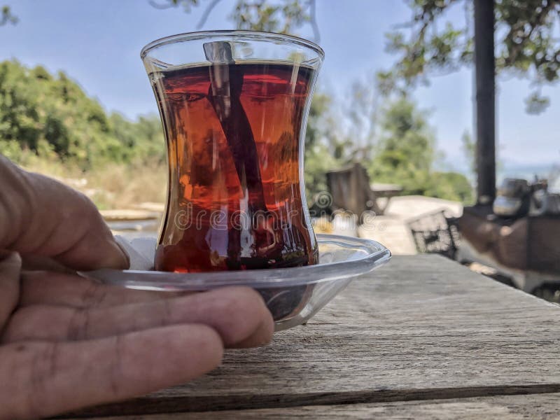 Hand Holding a Glass of Turkish Tea on a Wooden Table Stock Image ...