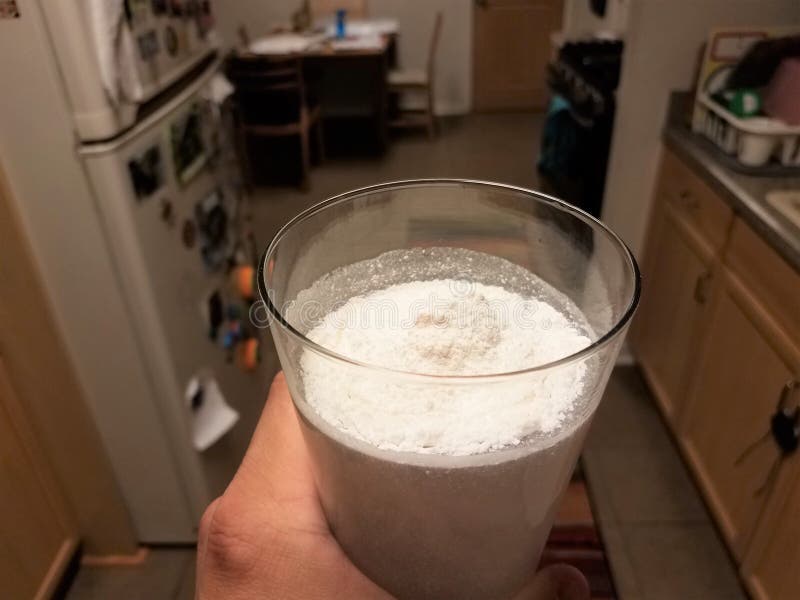 Hand Holding Glass of Water and White Powder in Kitchen Stock Image ...