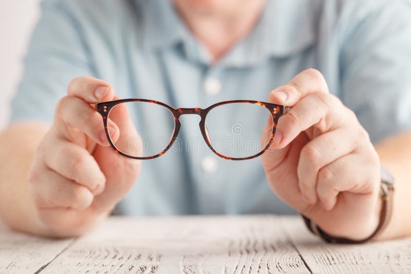 Hand holding glasses stock photo. Image of eyesight, table - 95865198
