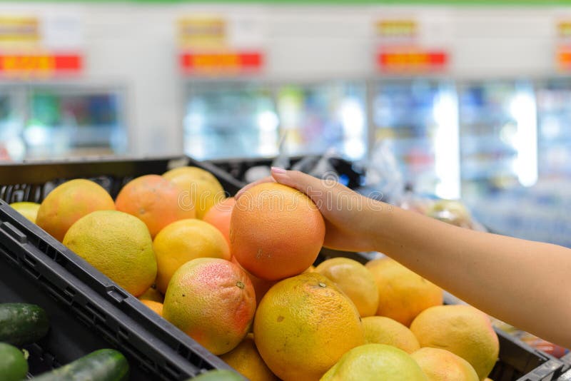 Hand Holding a Grapefruit in a Supermarket Stock Image - Image of ...