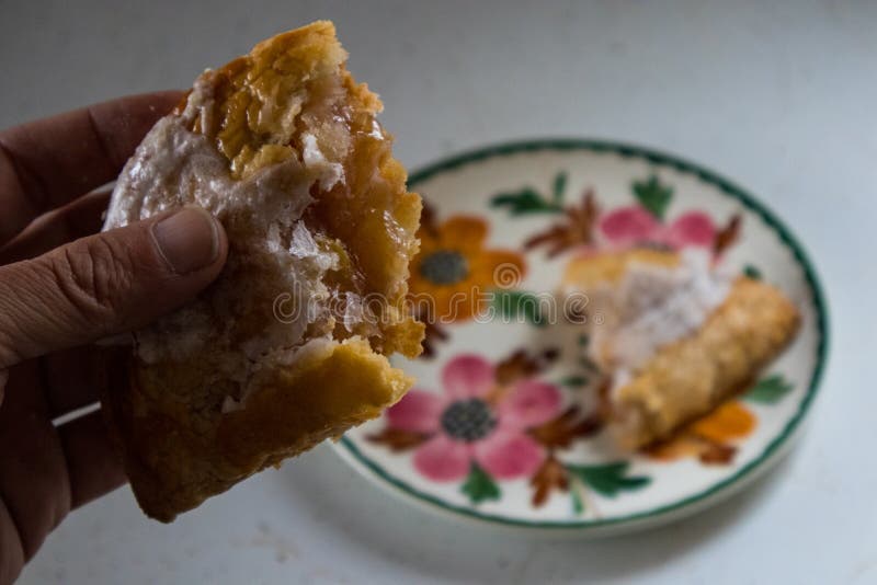 Hand Holding Half of a Broken Apple Hand-pie Turnover Above a Plate ...