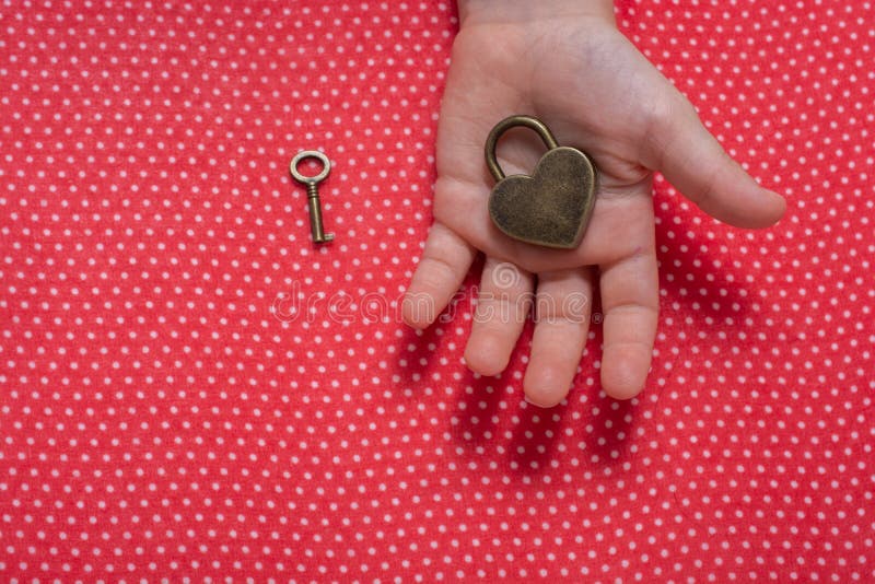 Hand Holding a Heart Shaped Lock and Key on Red Background Stock Photo ...