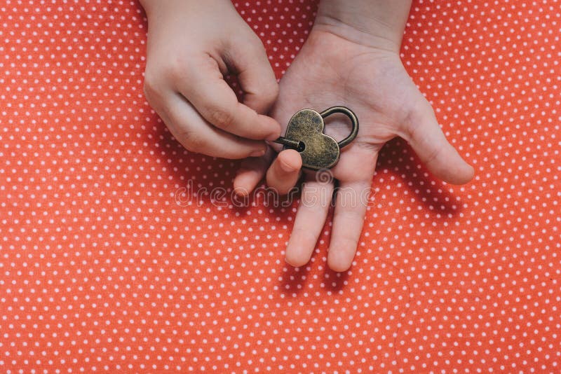 Hand Holding a Heart Shaped Lock and Key on Red Background Stock Photo ...