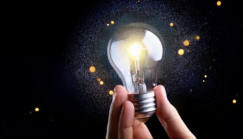 Hand Holding Illuminated Lightbulb with Glowing Particles on Dark ...