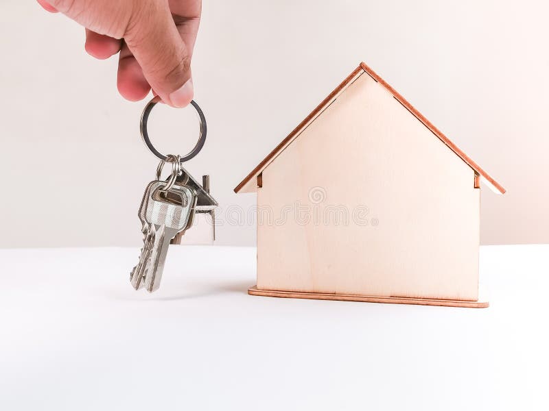 Hand Holding Keys with House Miniature on the Table. Stock Photo ...