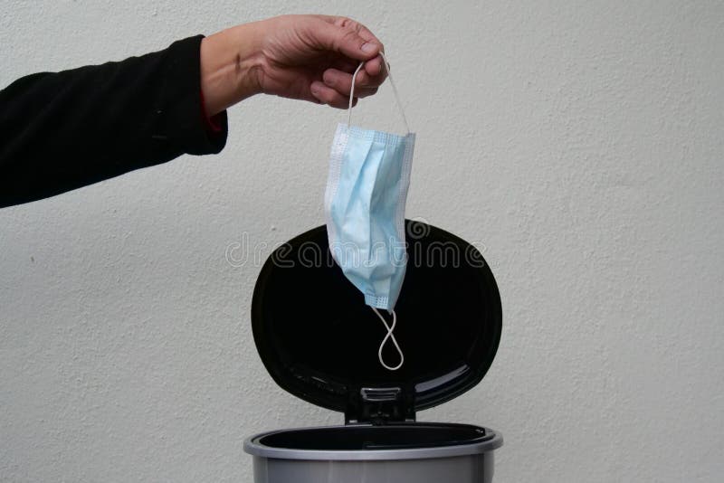 Hand Holding Light Blue Disposable Face Mask before Throwing it Away in ...