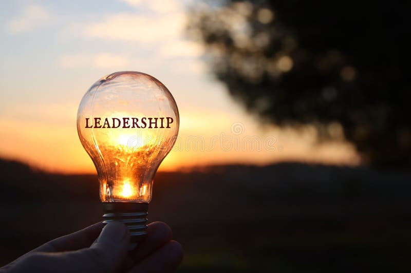 Hand Holding Light Bulb with the Text Leadership in Front of the Bright ...