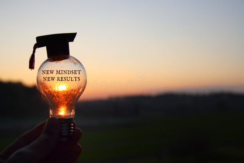Hand Holding Light Bulb with the Text New Mindset in Front of the ...