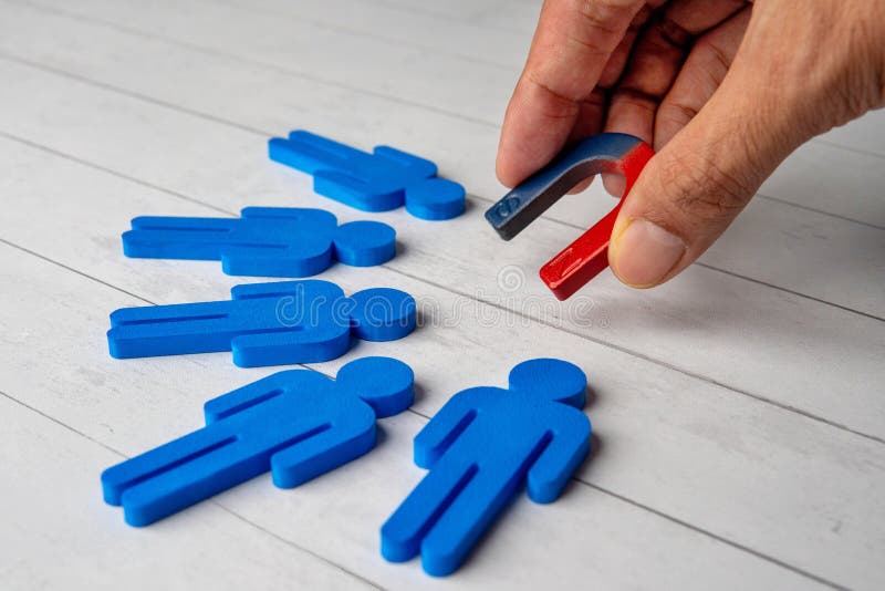 Hand Holding a Magnet Attracts a Blue Figures. Stock Image - Image of ...