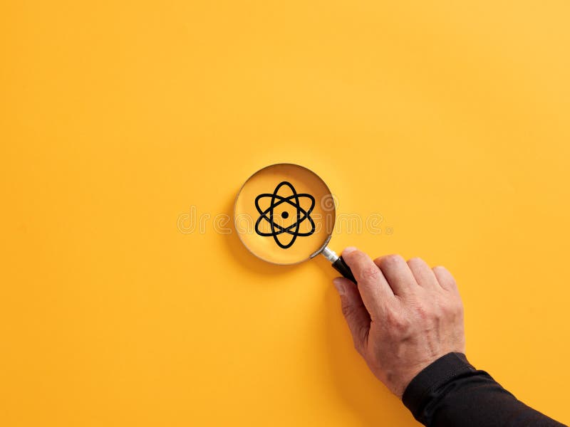 Hand Holding a Magnifier Over the Atom Symbol. Science and Scientific ...
