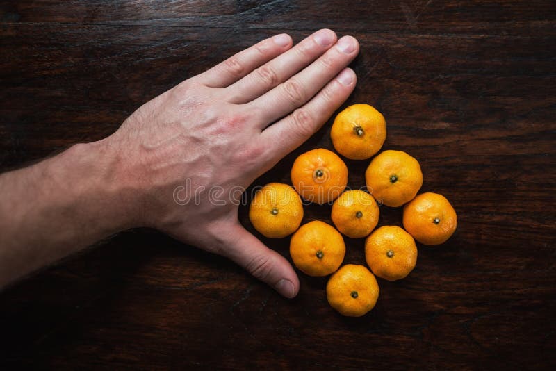 Hand Holding Mandarin on Wooden Table. Stock Photo - Image of crop ...