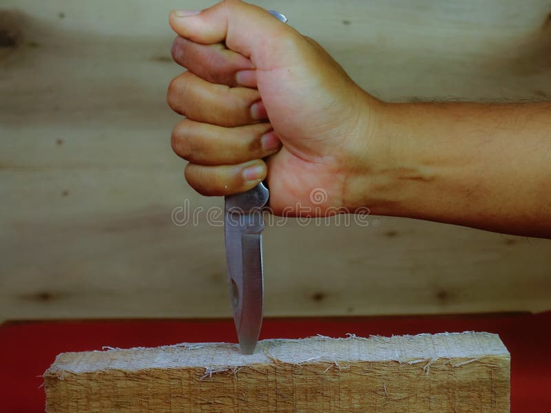 Hand Holding a Metal Knife that Stuck in the Wood Stock Image - Image ...