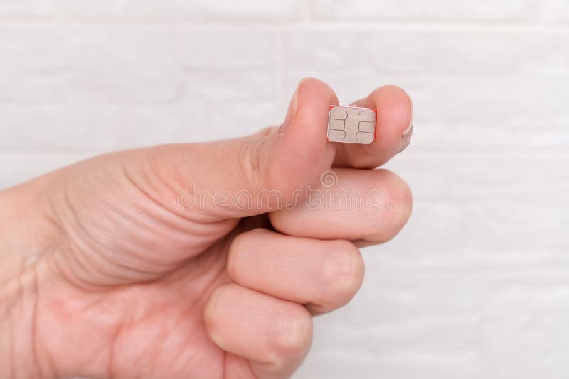 A Hand Holding Micro Sim Card in Fingers, Telecommunication Technology ...