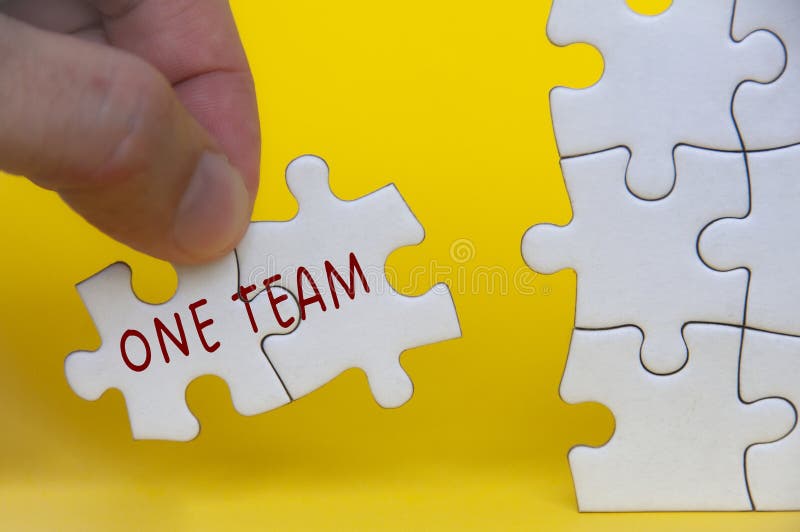 Hand Holding Missing Jigsaw Puzzle with One Team Text. Teamwork Concept ...