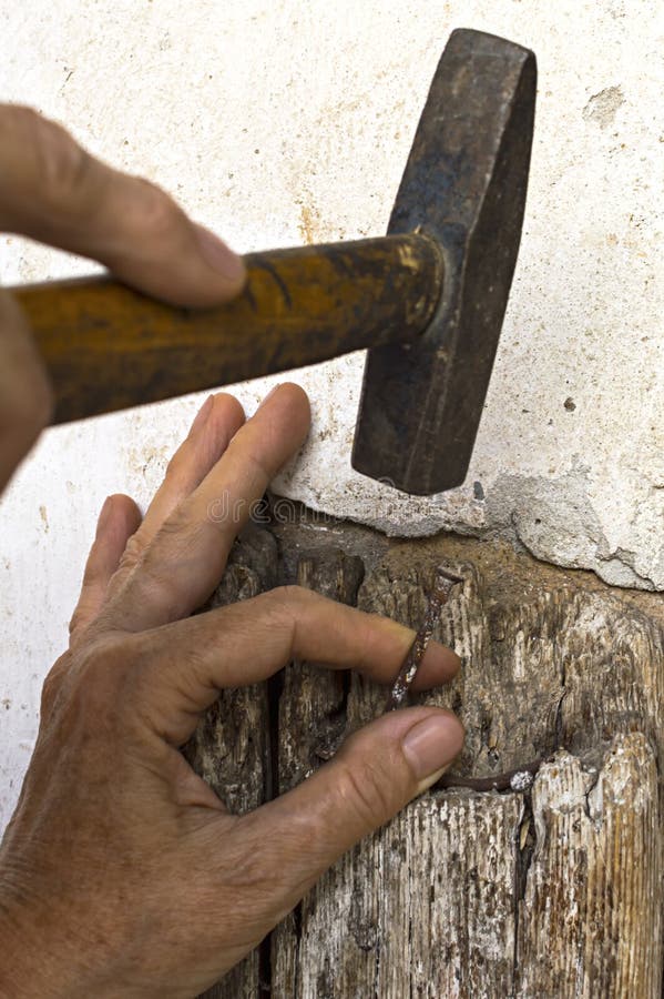 Hand Holding Nail and Hammer Stock Photo - Image of holding, wall: 42757388