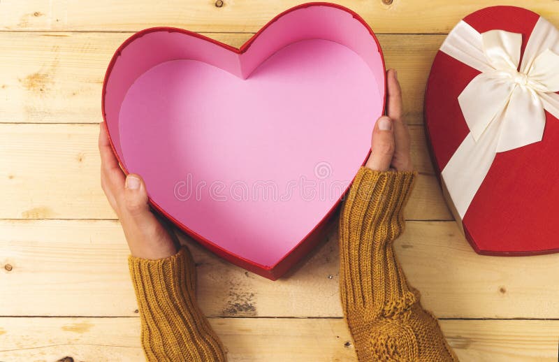 Hand Holding Open Heart Shaped Box on Wood Table. Stock Image - Image ...