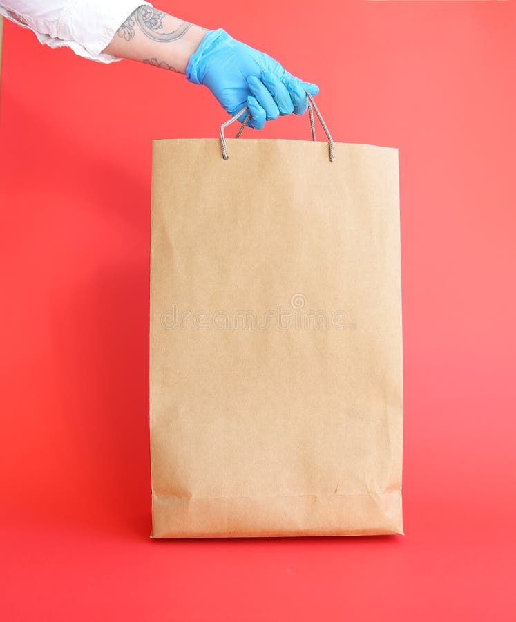 Hand Holding a Paper Bag on a Red, Isolated Stock Photo - Image of ...