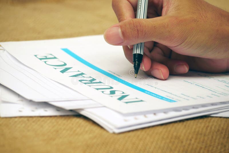 Hand Holding Pen Filling Out Insurance Form on Paperwork Surface Stock ...