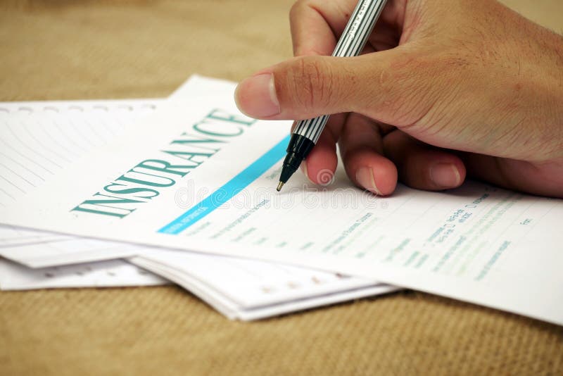 Hand Holding Pen Filling Out Insurance Form on Paperwork Surface Stock ...