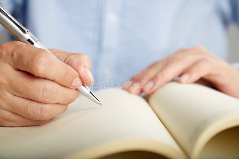 Hand Holding a Pen and Writing in Notebook,Close Up Stock Image - Image ...