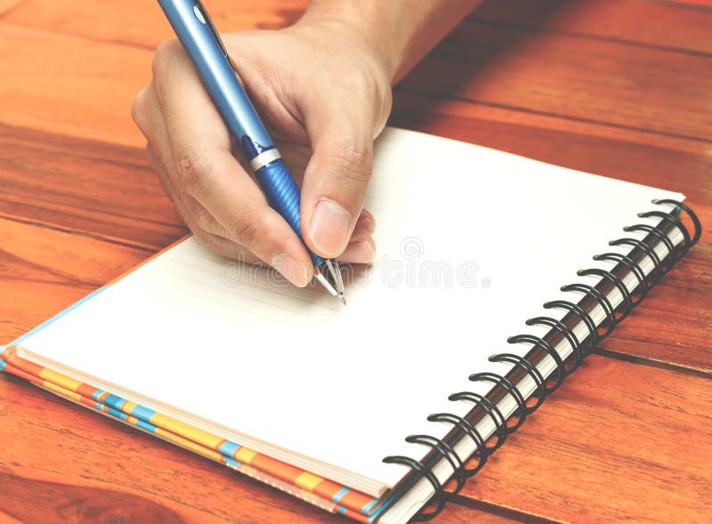 Hand Holding a Pen Writing on the Notebook Stock Image - Image of ...