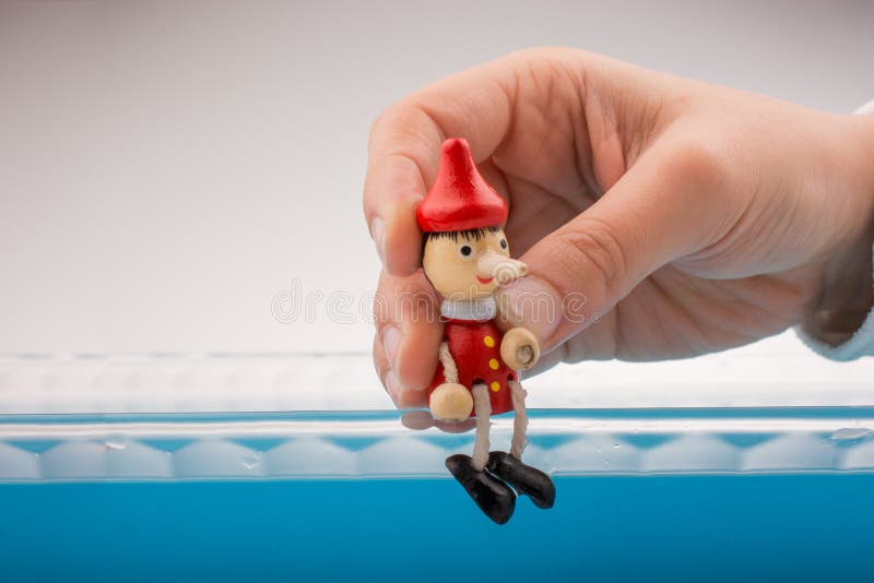 Hand Holding Pinocchio on in Water Stock Image - Image of character ...
