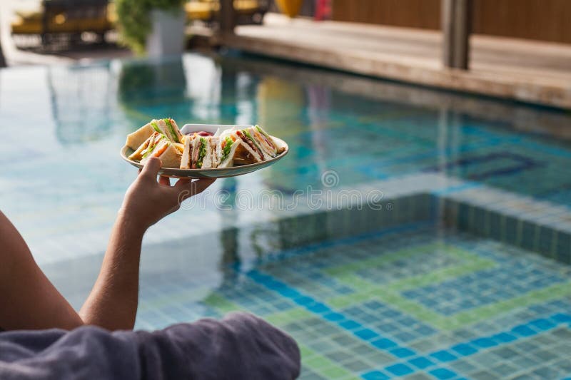 Hand Holding Plate of Sandwiches by Swimming Pool. Stock Photo - Image ...