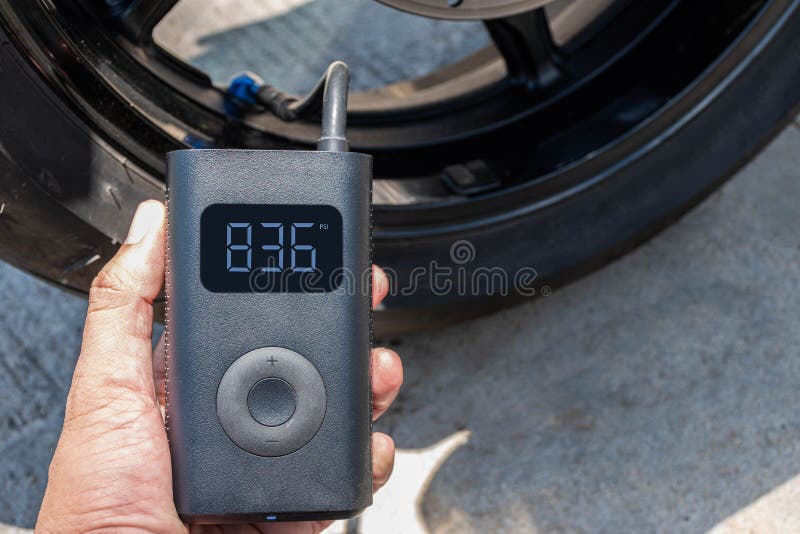 Hand Holding a Portable Inflator is Inflating a Motorcycle Tire Stock ...