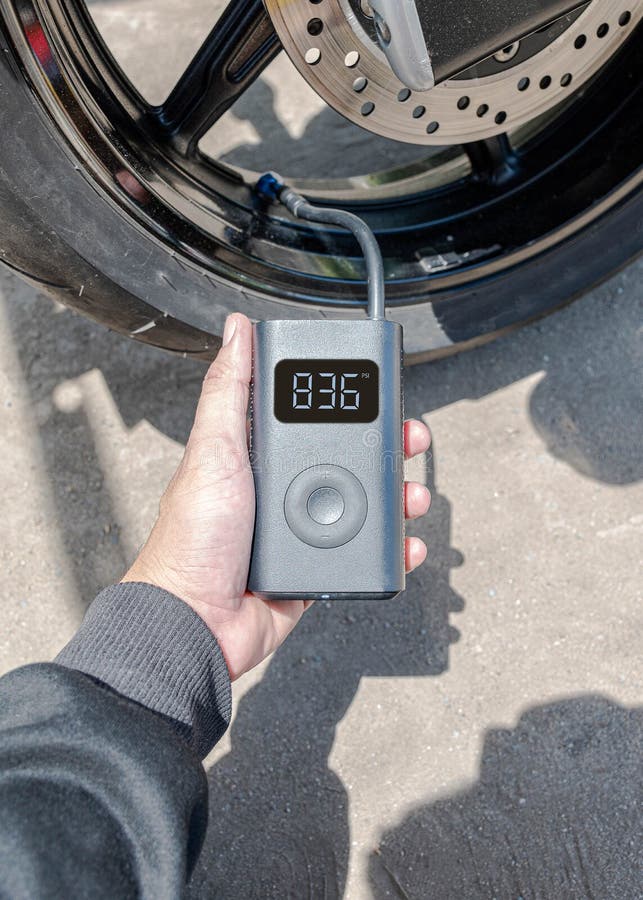 Hand Holding a Portable Inflator is Inflating a Motorcycle Tire Stock ...