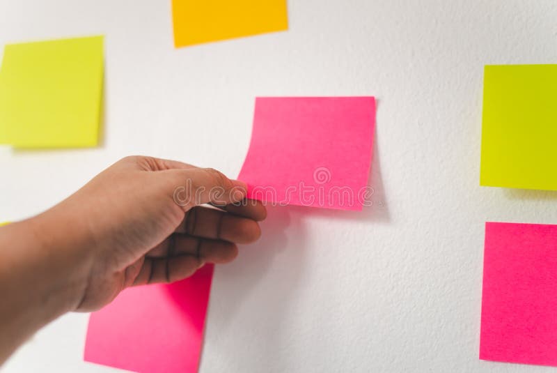 The Hand is Holding the Post it Notes Attached To the Wall. Concept ...