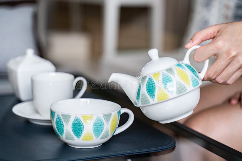 Hand Holding Pot Pour Tea into a Cup Stock Photo - Image of design ...