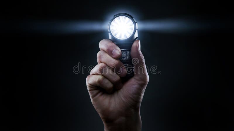 A Hand Holding a Powerful Flashlight Emitting a Bright Beam of Light in ...