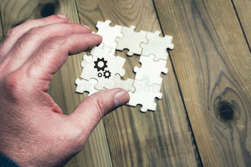 A Hand is Holding a Puzzle Piece with a Gear on it Stock Photo - Image ...