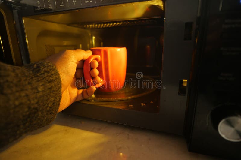 Hand Holding Red Mug while Using Microwave at Home Stock Photo - Image ...