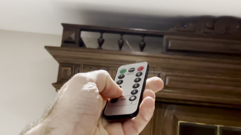 Hand Holding a Remote Control Adjusting Blinking Settings of String ...