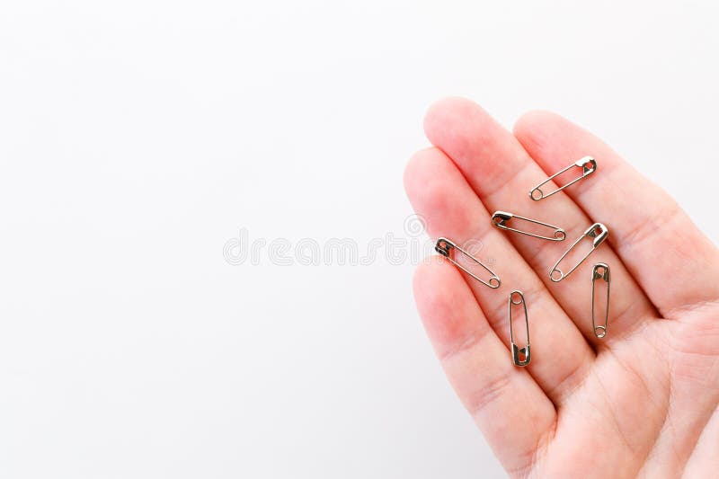 Hand holding safety pins stock photo. Image of clothes - 333767130