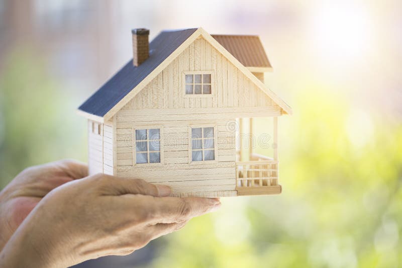 A Hand Holding a Small Model House. Home Protection Concept Stock Image ...