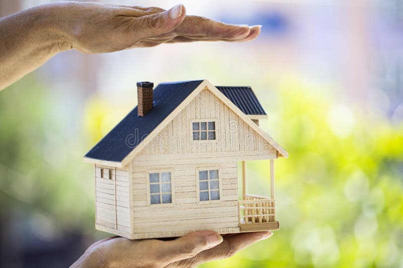 A Hand Holding a Small Model House. Home Protection Concept Stock Photo ...