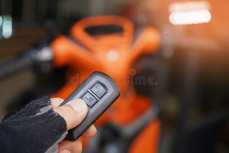 Hand Holding Smart Key or Remote Control with Motorcycle Background ...