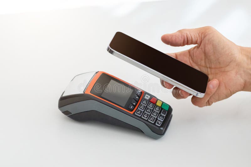 Hand Holding a Smartphone Above a Card Payment Terminal, Indicating a ...