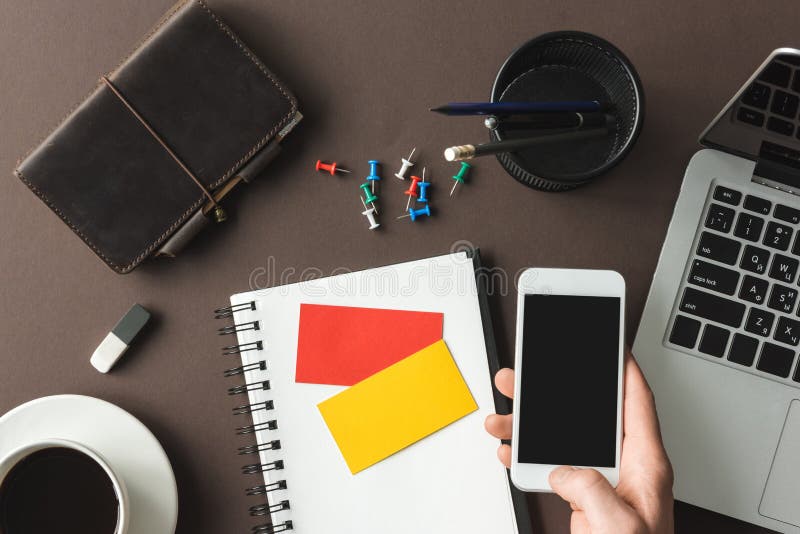 Hand Holding Smartphone with Notebook and Stickers on Home Office Table ...